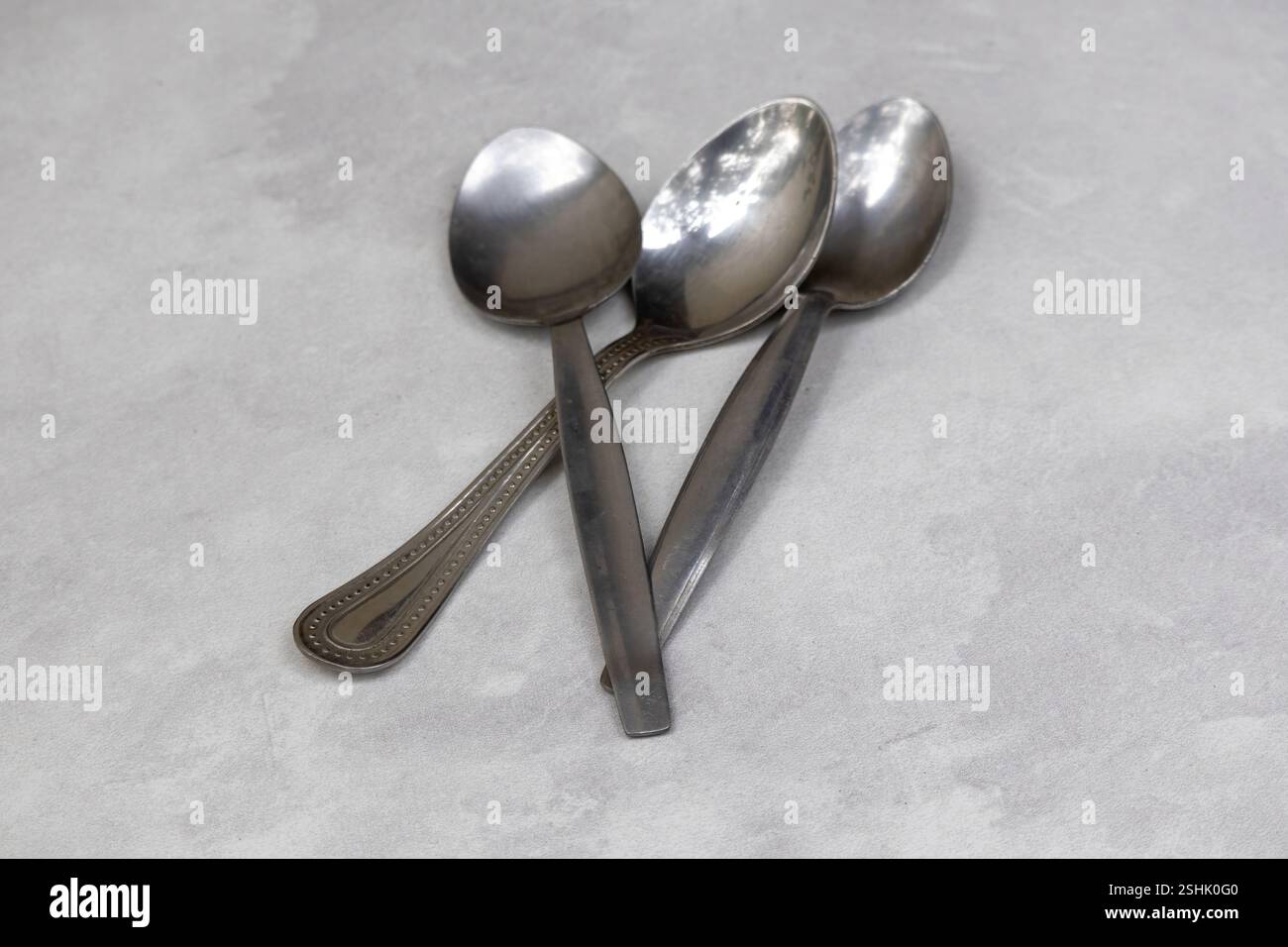Three shiny silver spoons, made of stainless steel Stock Photo - Alamy