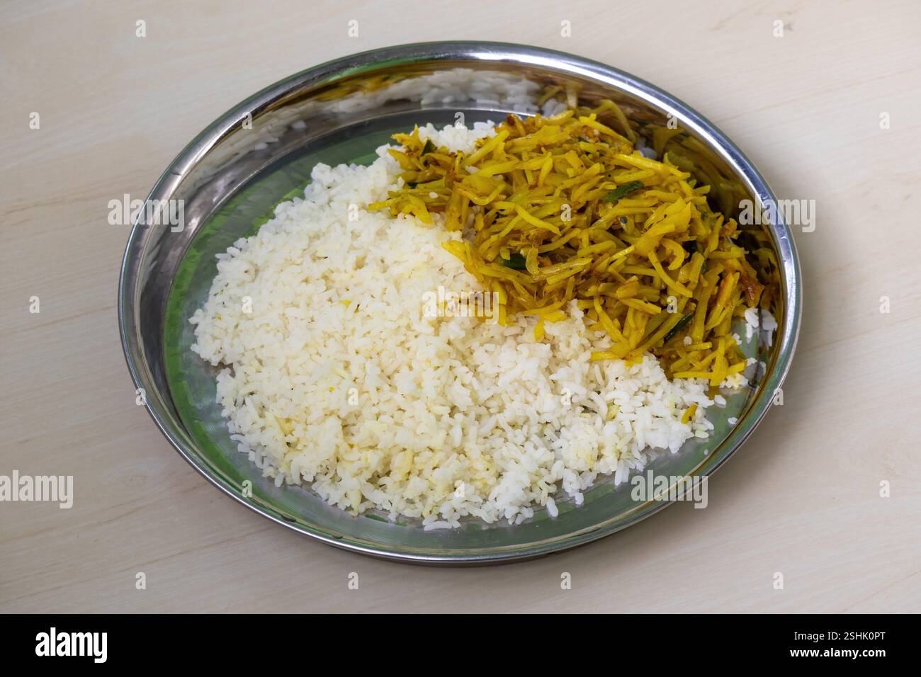 Plain white rice and thinly sliced potato fry (aloo bhaji) served on a ...