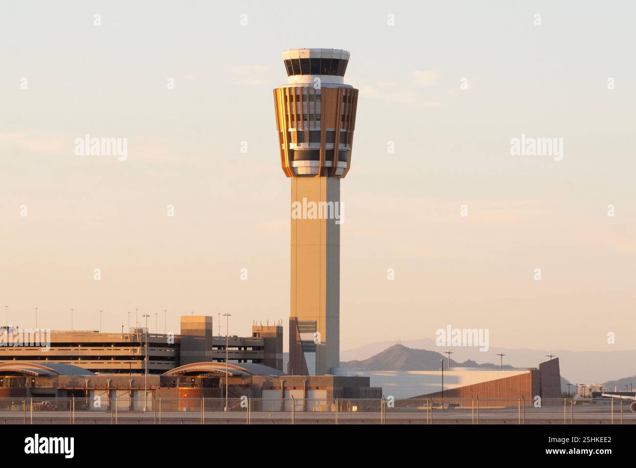The towering airport control tower stands tall, overseeing the busy ...