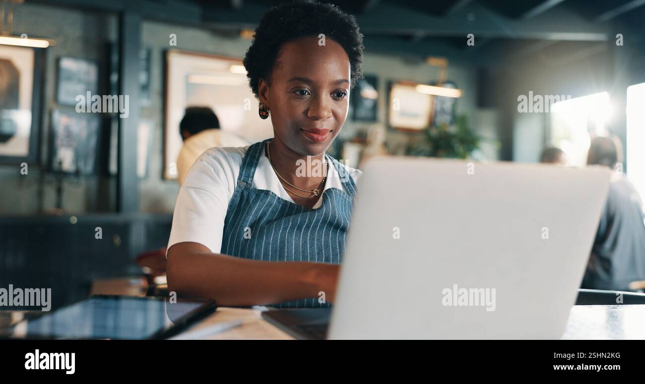 Typing, laptop and planning with black woman in cafe for product ...