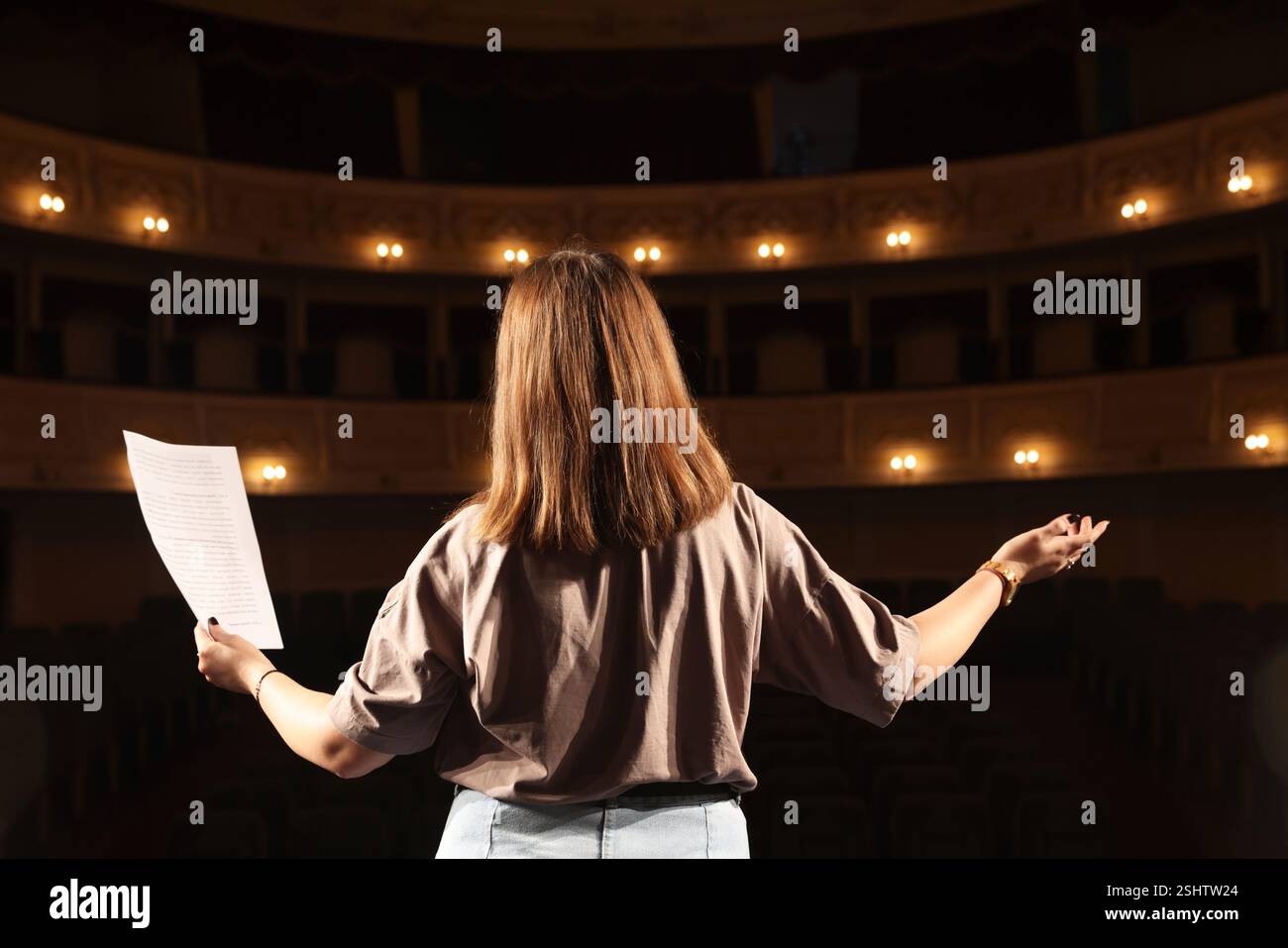 Professional actress rehearsing on stage in theatre, back view Stock ...