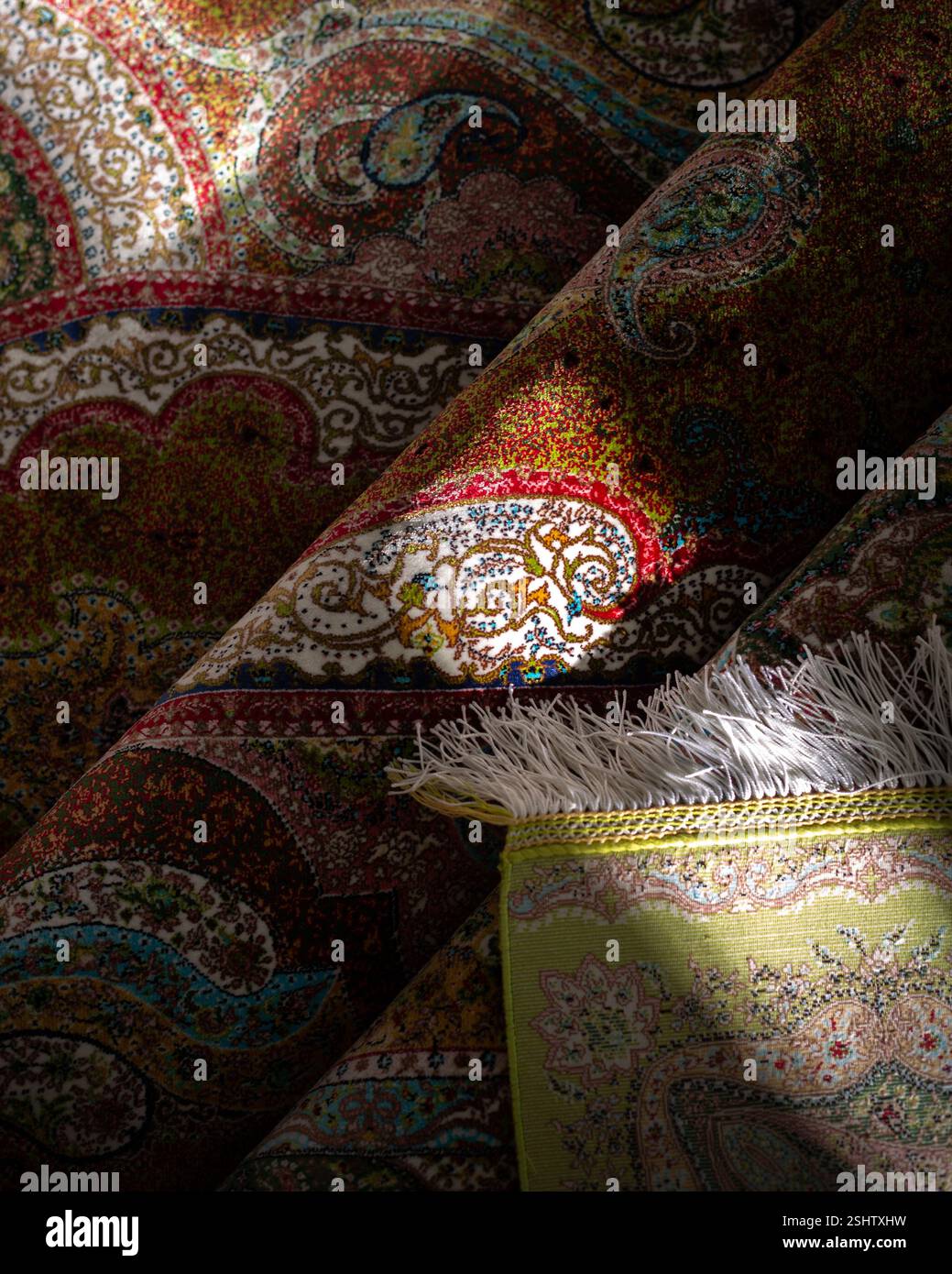 Tightly rolled Persian rug with a vibrant paisley (Boteh) pattern and ...