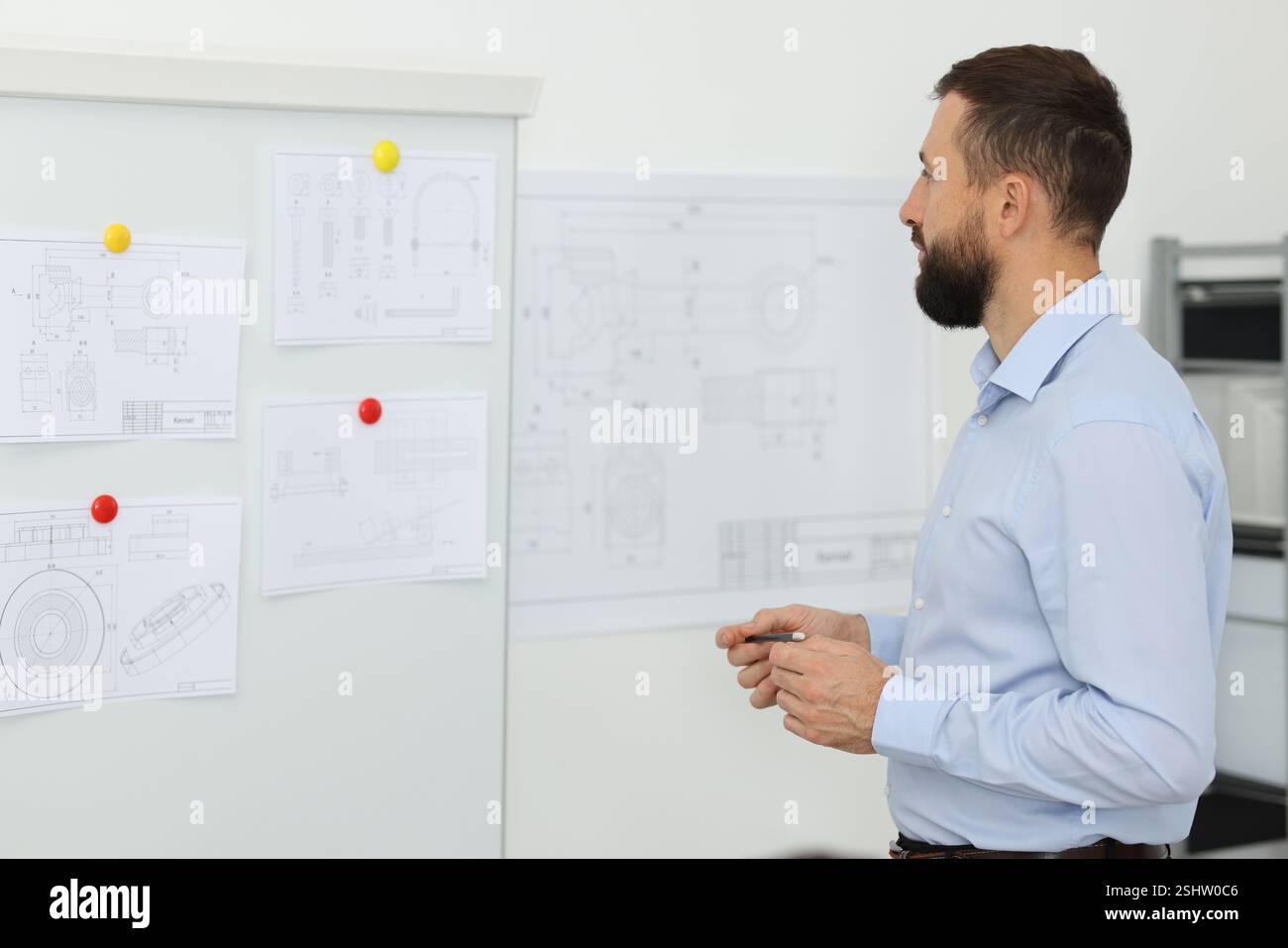 Man making presentation with engineering drawings to his colleagues in ...