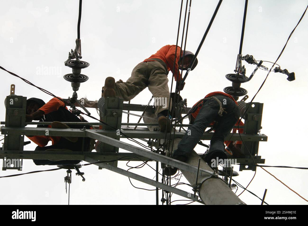 Electric workers performing maintenance on high-voltage power lines in ...
