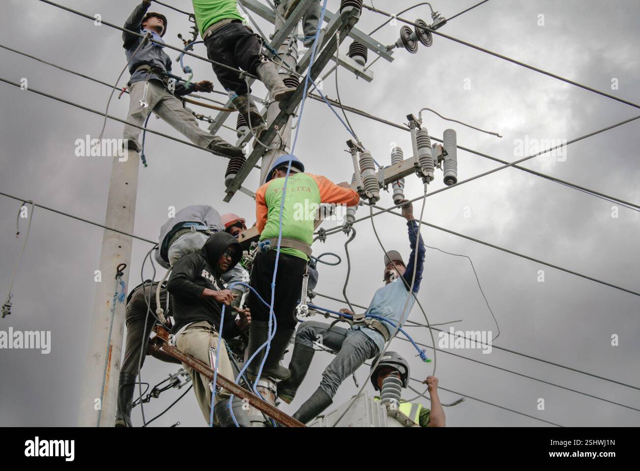 Group of electrical workers performing maintenance on high voltage ...