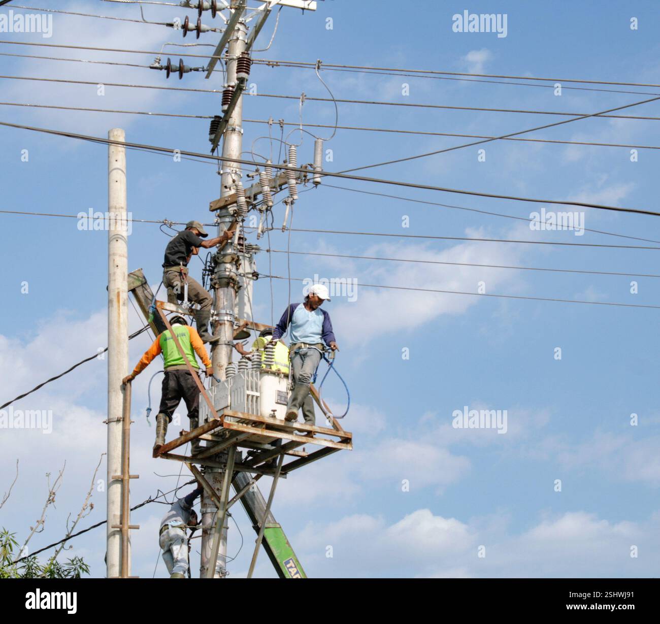 A group of electrical workers conducting maintenance on utility power ...