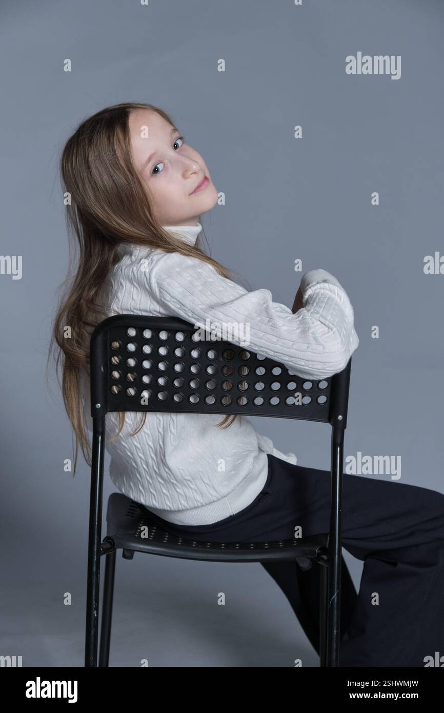 Child looking back with a serene expression, comfortably dressed in ...