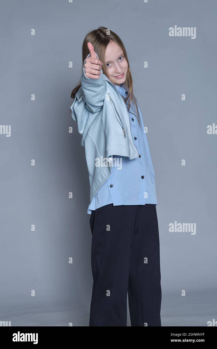 Youthful joy meets chic style in a girl's cheerful pose. A great ...