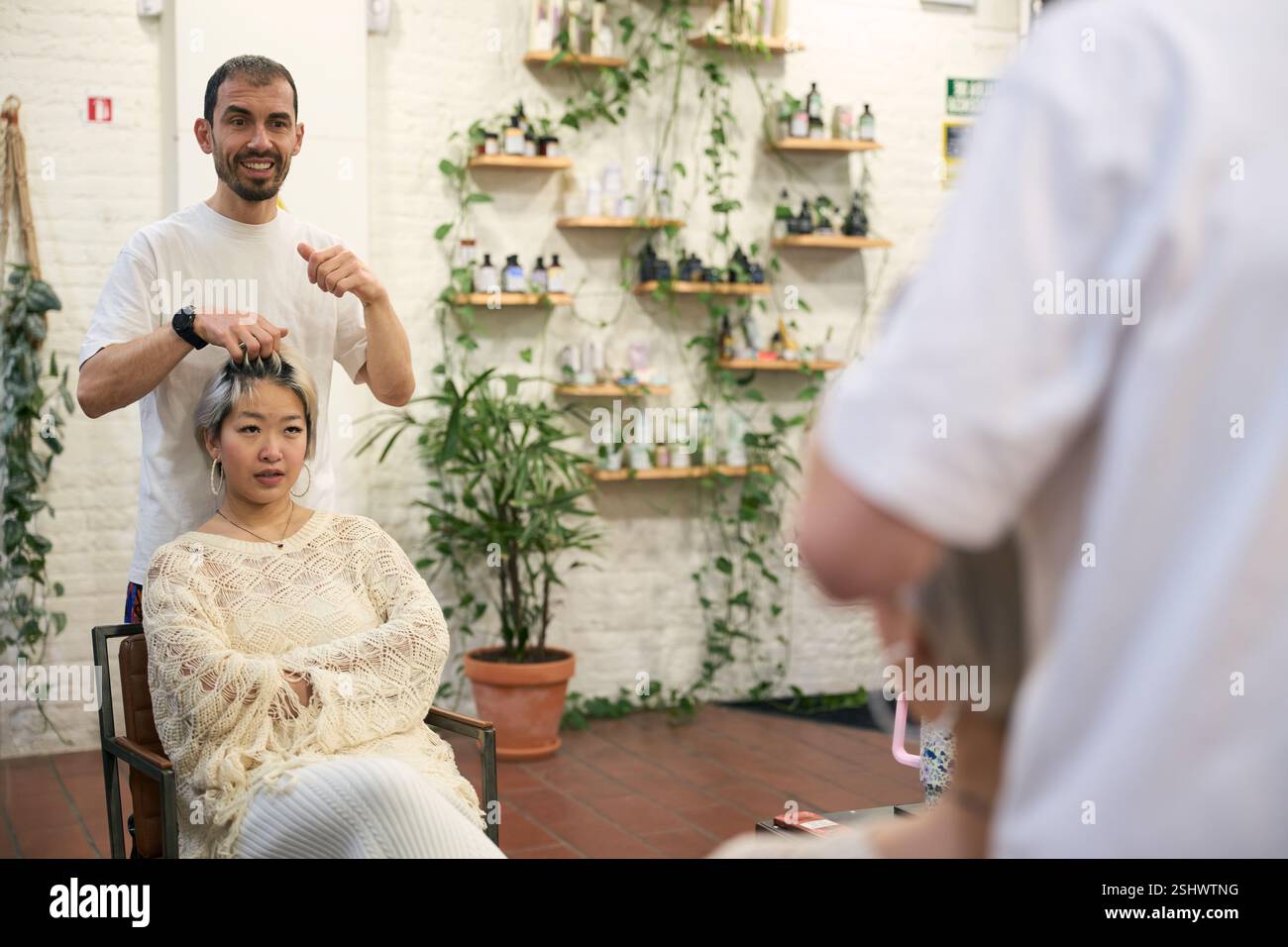 Hairdresser showing new hairstyle on young female model in salon Stock ...