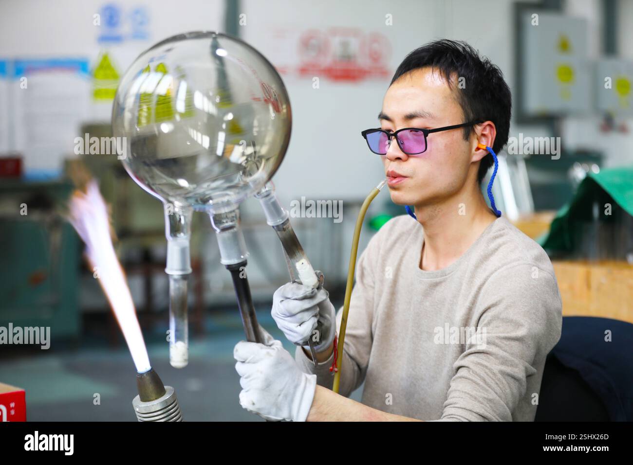 A technician produces glass instruments at a workshop in Chongqing ...