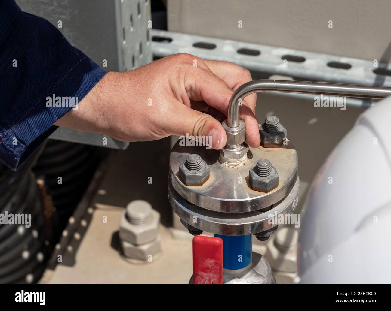 Close-up of an engineer adjusting a pipeline flange connection ...