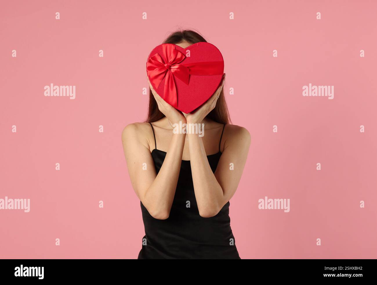 Happy Valentine's Day. Woman hiding behind heart shaped gift box on ...