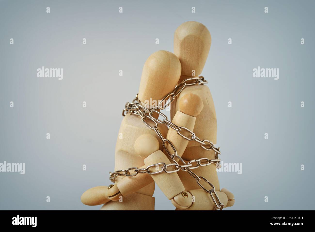 Two wooden mannequins bound by chains - Concept of toxic relationship and emotional dependence ...