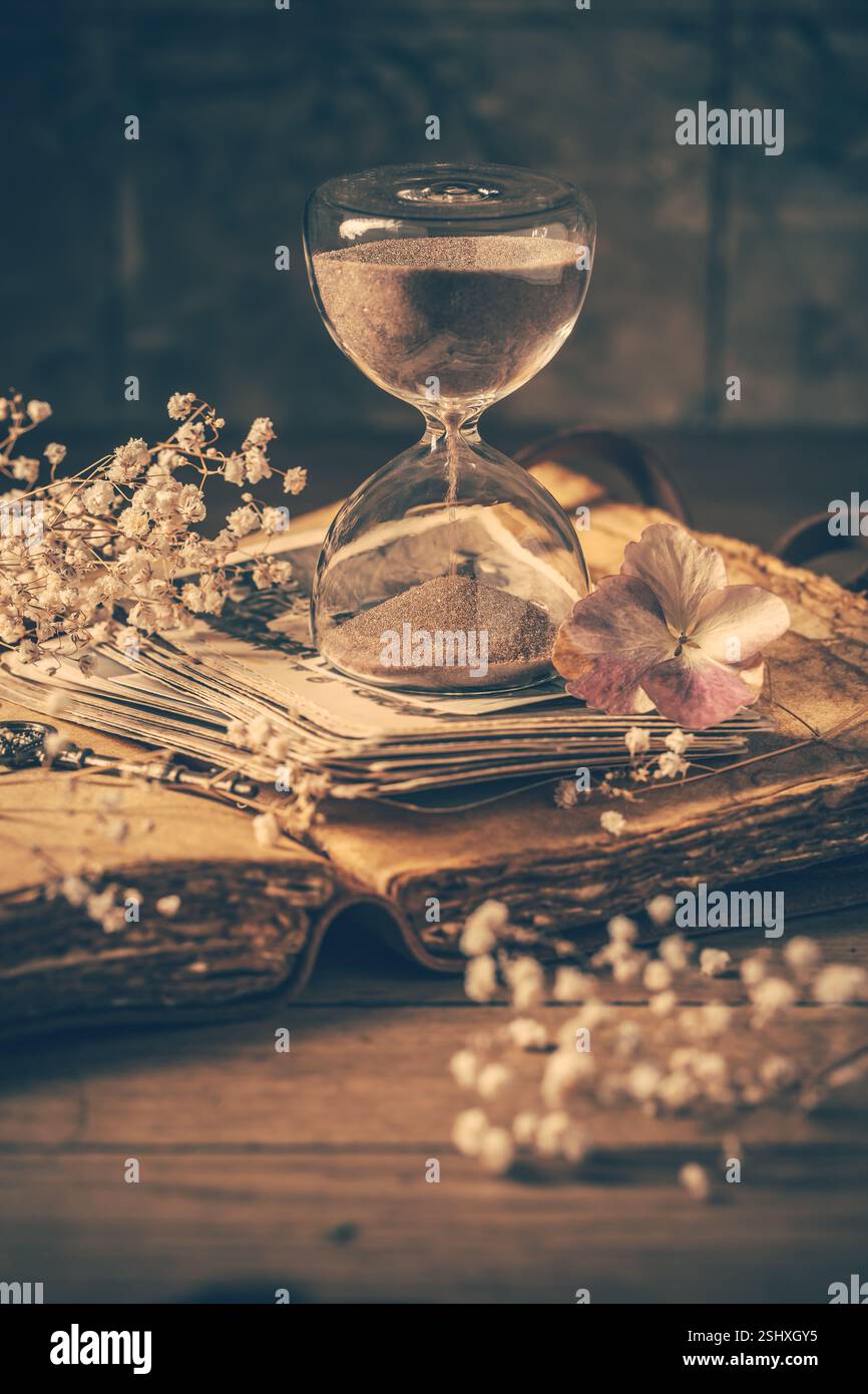 Hourglass with old book. Symbol of passing time and memories ...
