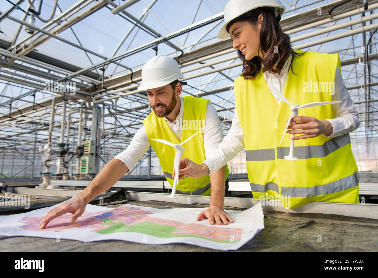 Two engineers discussing the construction plan and looking involved ...