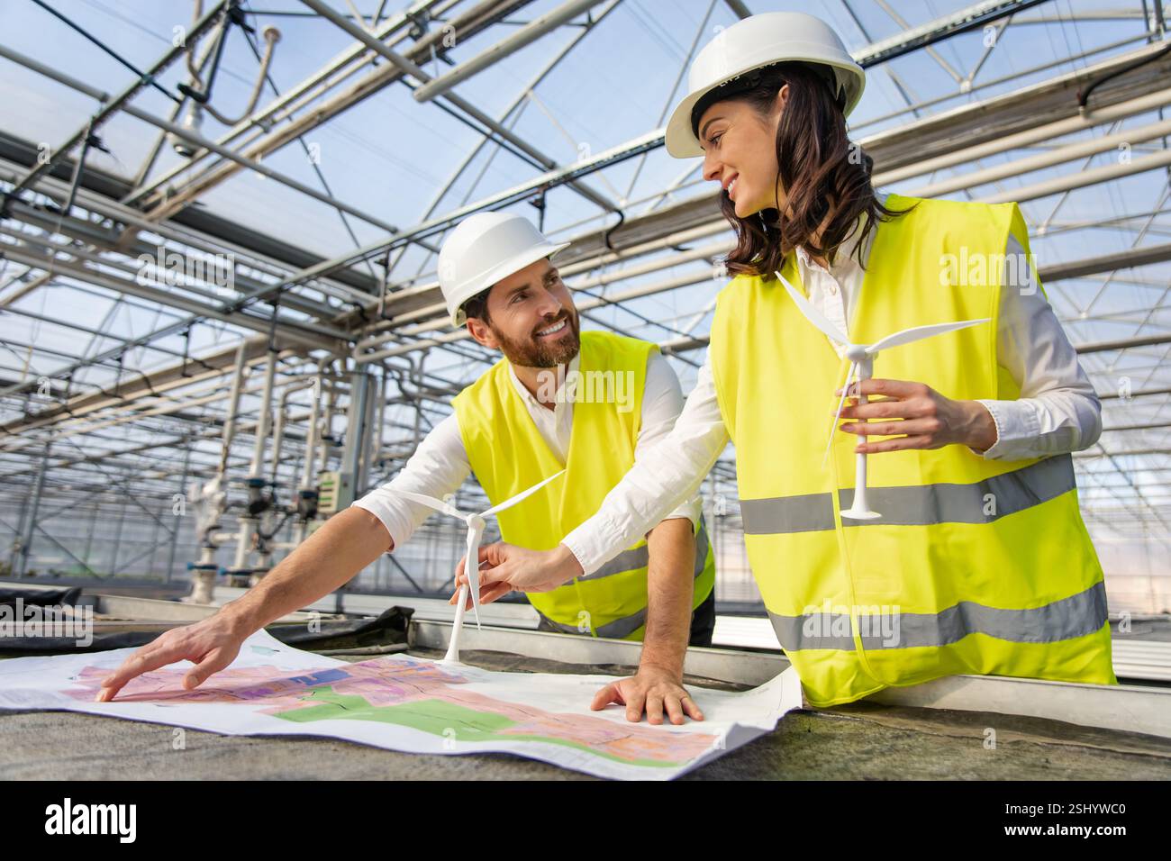 Two engineers discussing the construction plan and looking involved ...