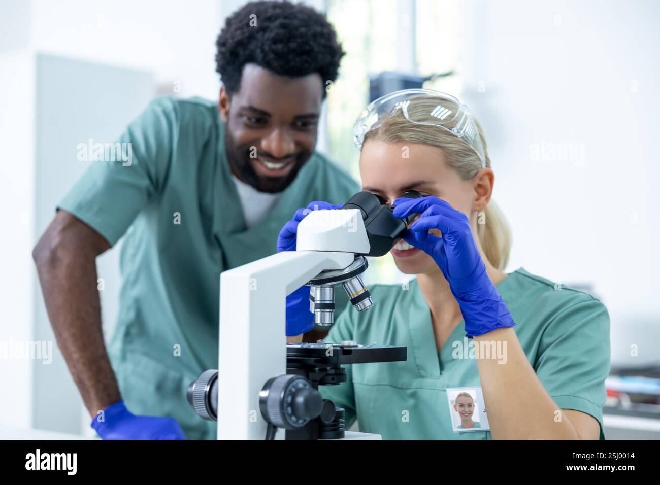 Multi-ethnic team of scientists using microscope in university lab Stock Photo - Alamy