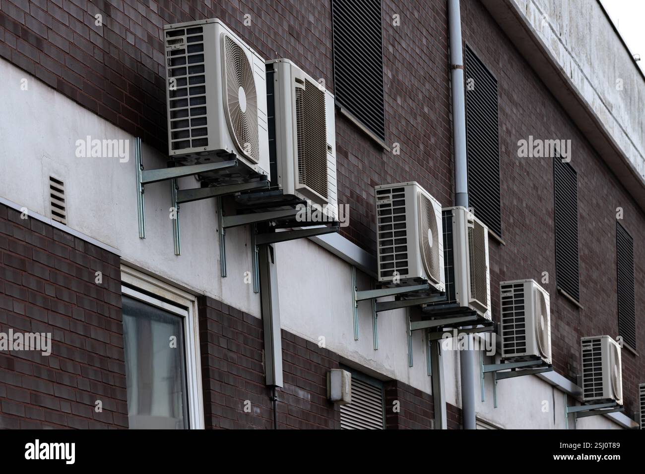 Multiple air conditioning units are installed outside a residential ...