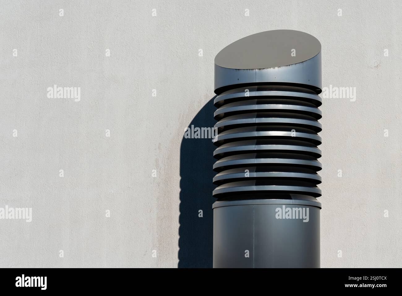 A sleek modern vent with a rounded top and vertical slats protrudes ...