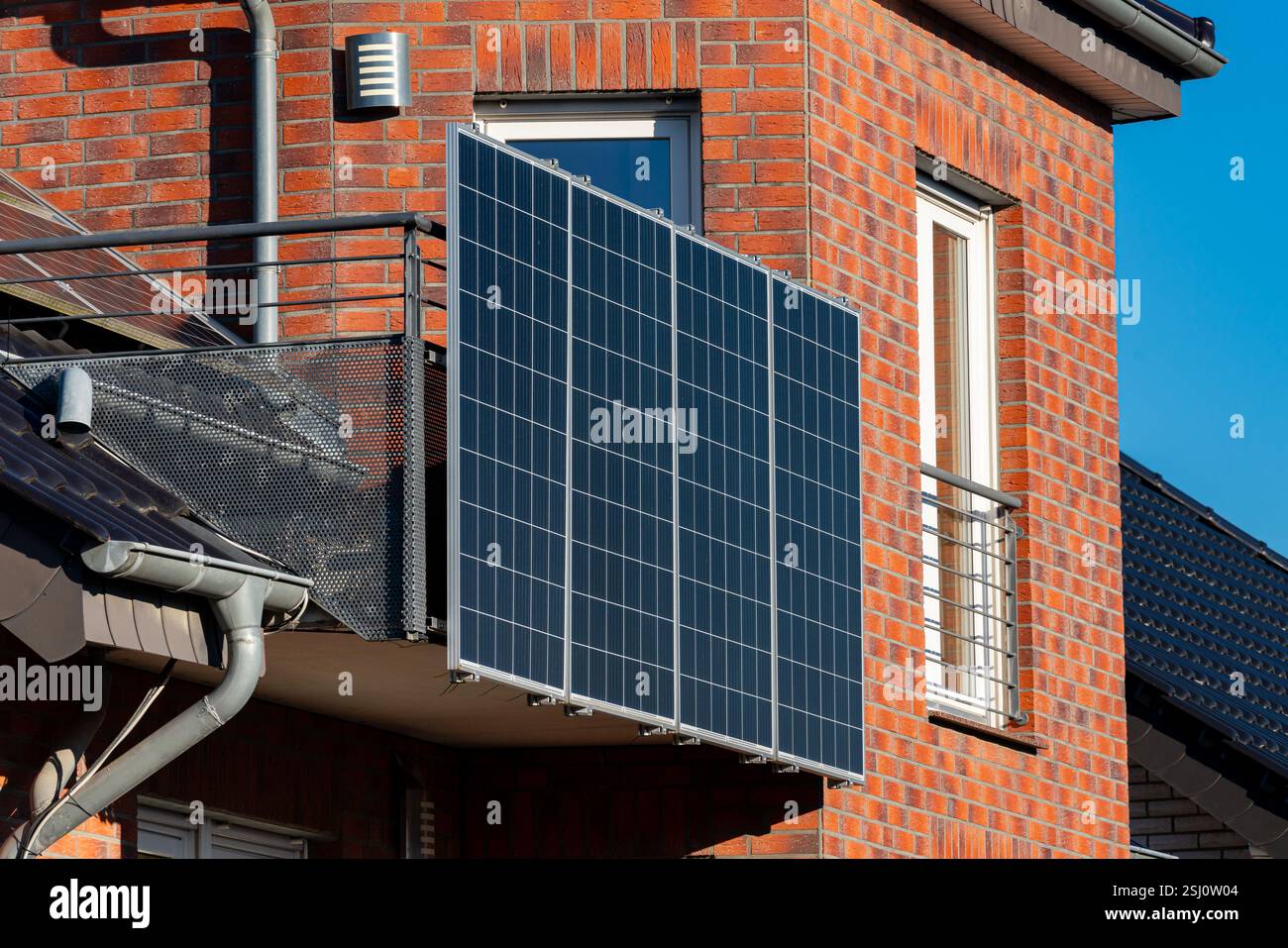 Solar panels are mounted on the balcony of a contemporary brick ...