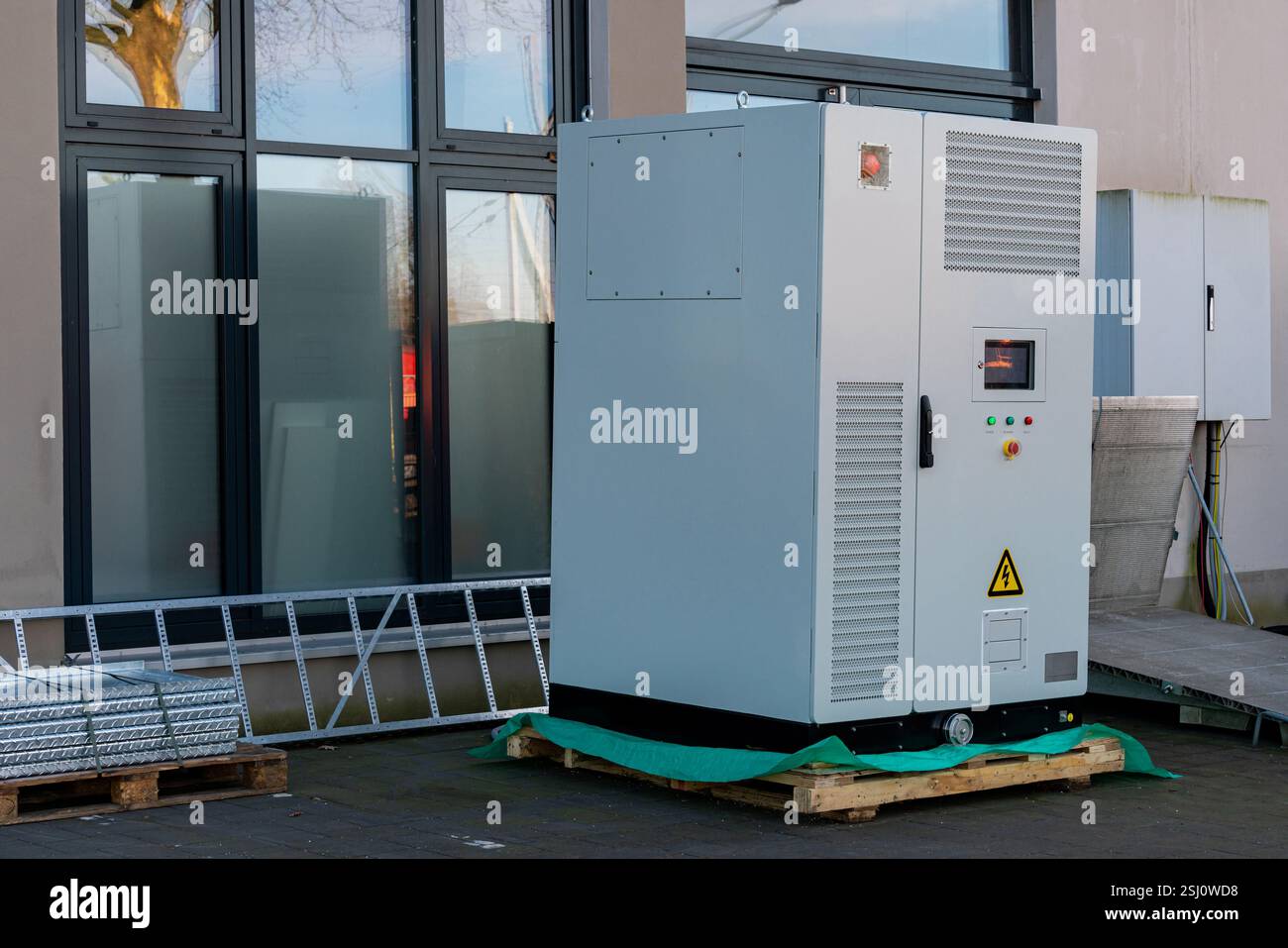 A large industrial cooling unit stands on a green mat outside a ...