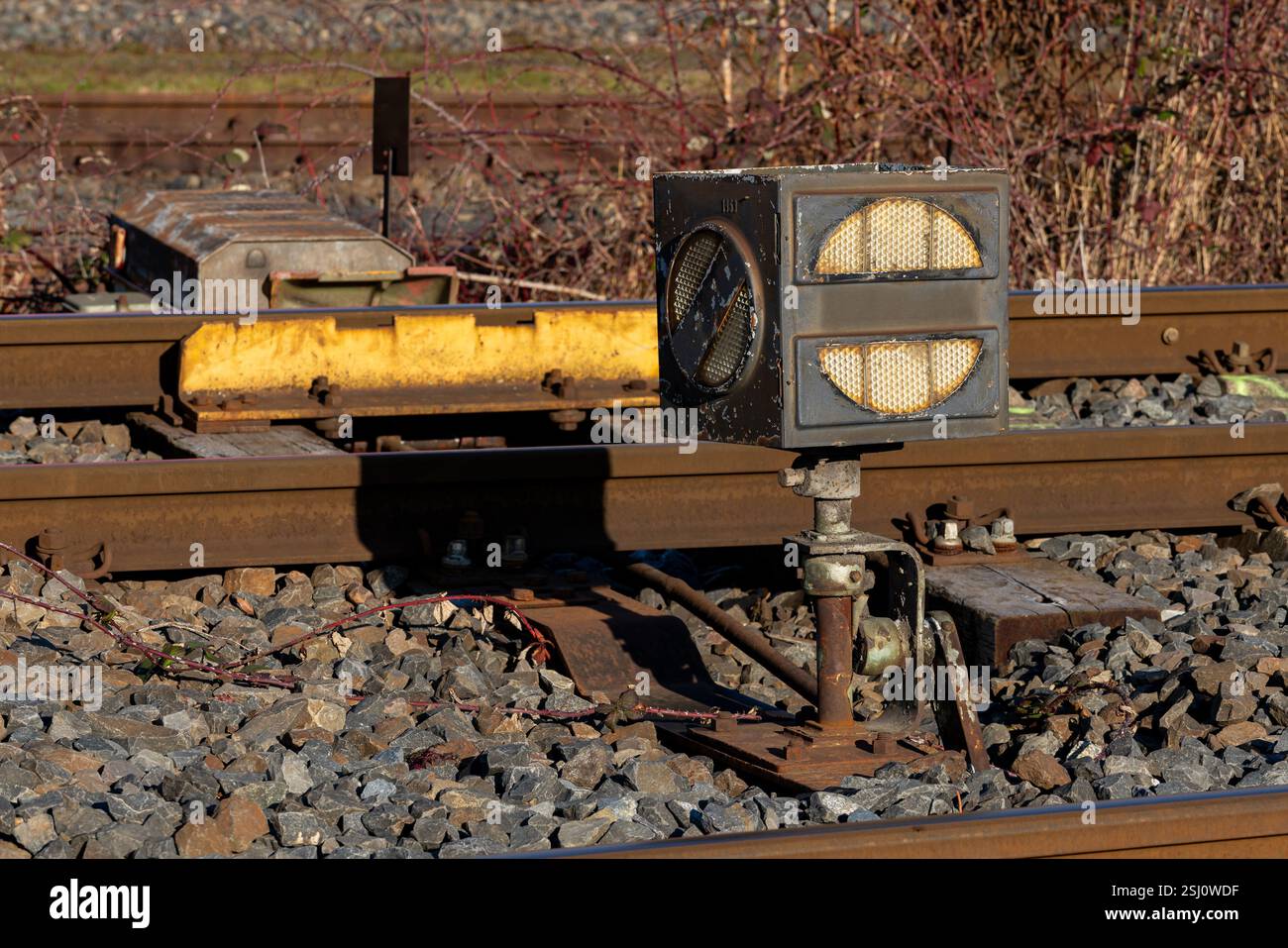 A railway signal control stands prominently beside the tracks, catching ...