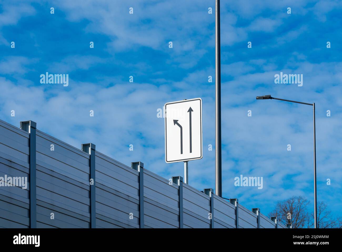 A traffic sign directs drivers to turn left and right, positioned next ...