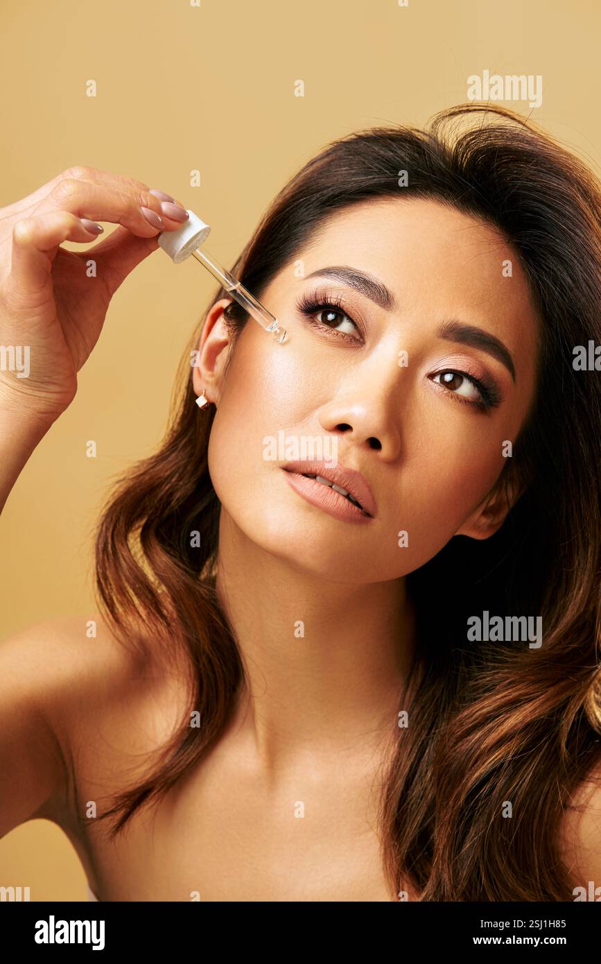 Beautiful woman applying facial serum using pipette dropper ...