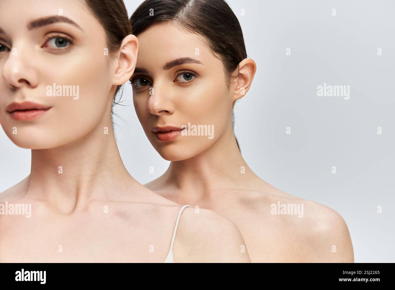 Two gorgeous sisters stand close together, their radiant features ...