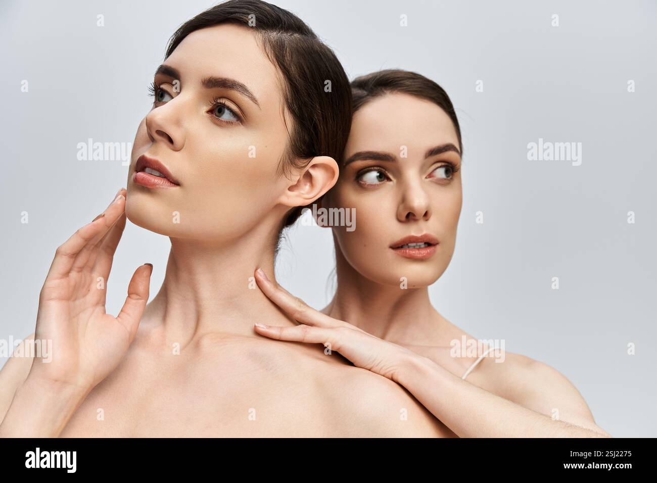 Elegant twin sisters pose thoughtfully, showcasing their close familial bond Stock Photo - Alamy