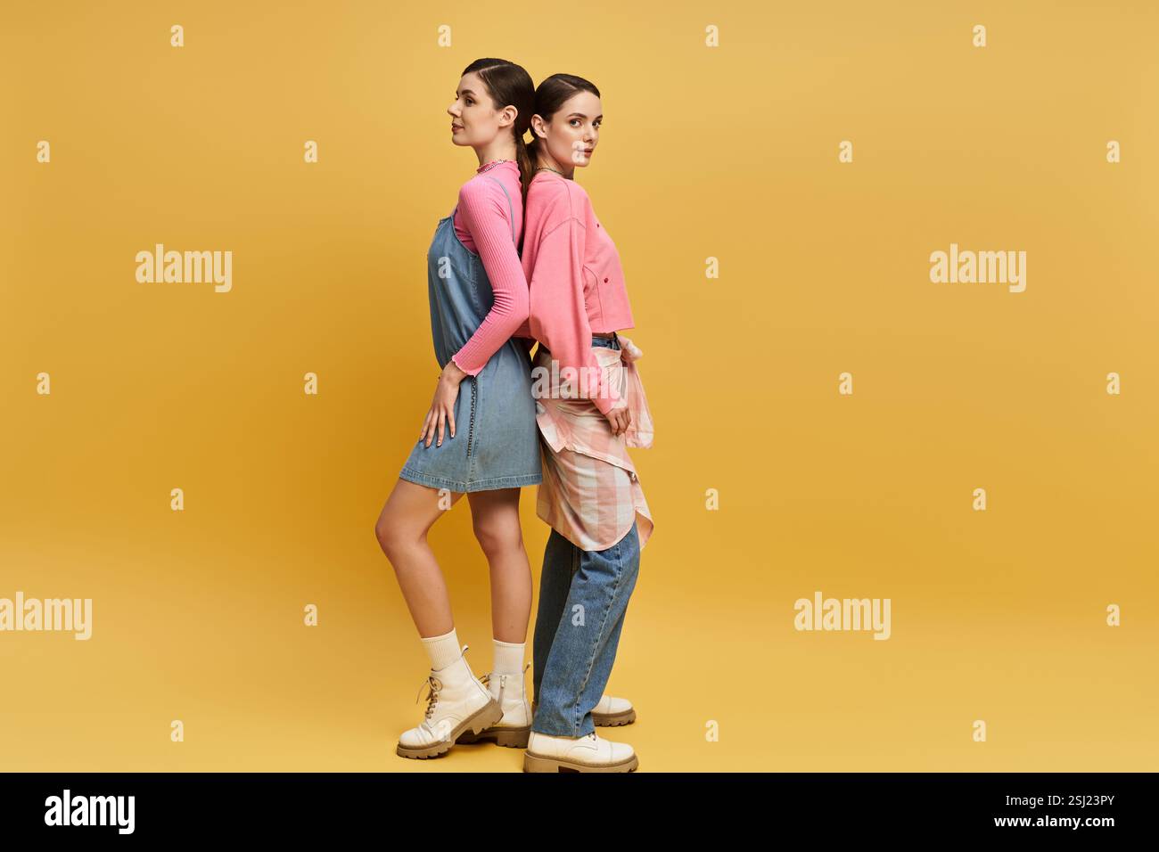 Two stunning twins pose back to back, flaunting their unique style on a ...