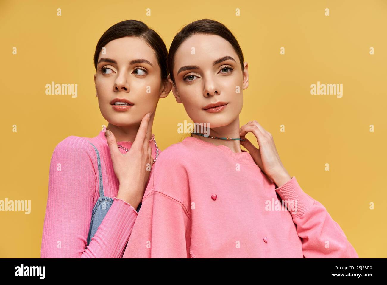 Two beautiful twin sisters pose elegantly with playful expressions and ...
