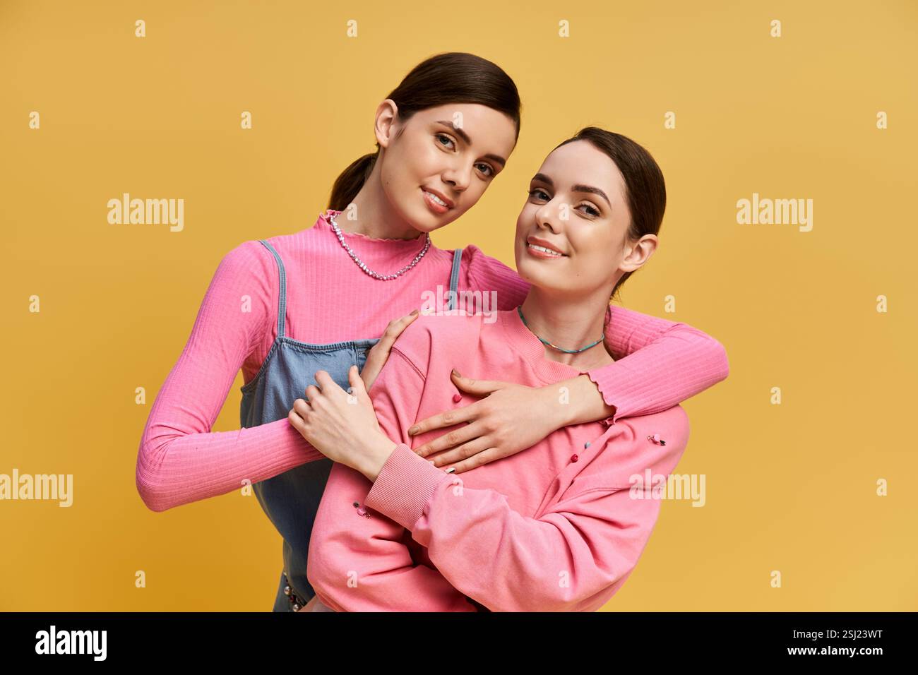 Two beautiful sisters showcase their close bond while wearing stylish ...