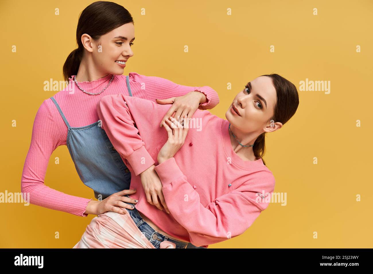 Two beautiful twin sisters showcase their fashion sense with playful ...