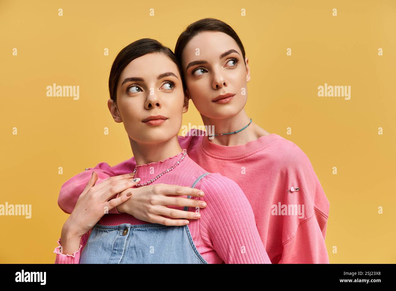 Two beautiful sisters share a playful moment while dressed in matching ...