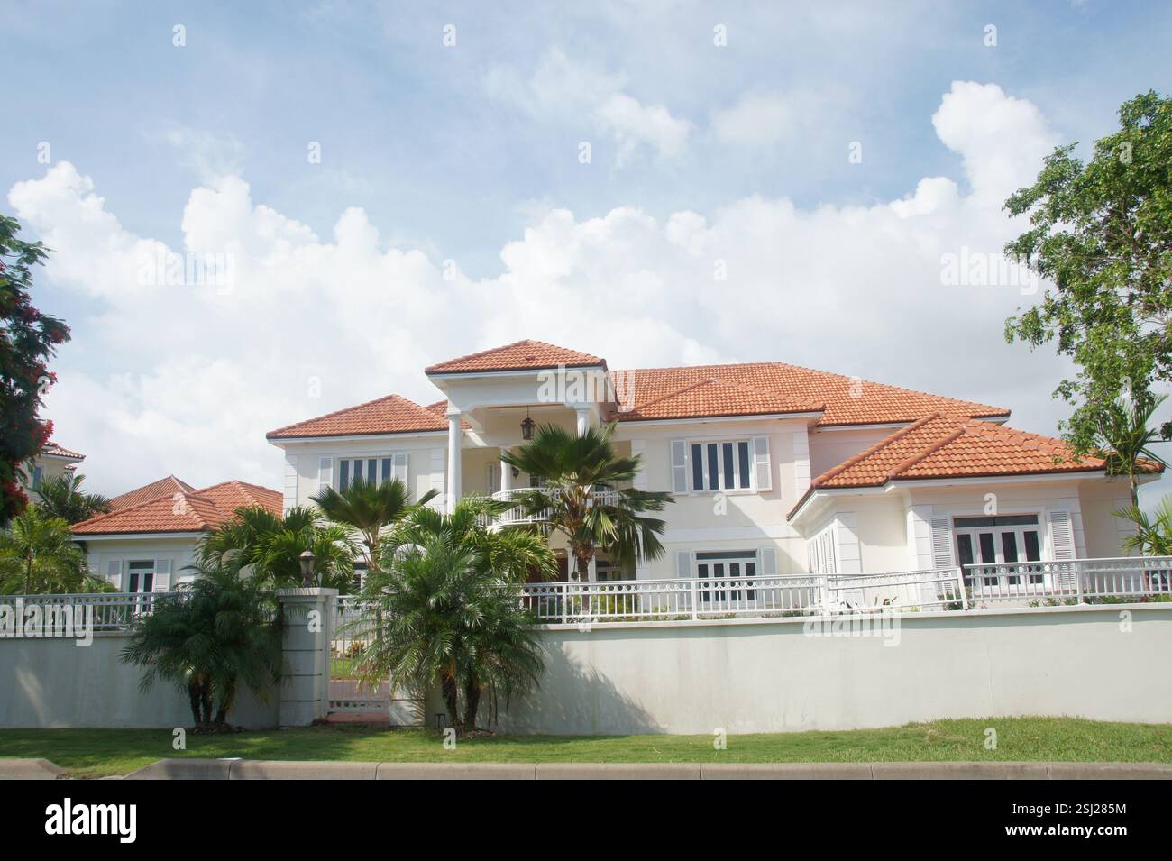 Large white mansion red tile roof surrounded palm trees white fence ...