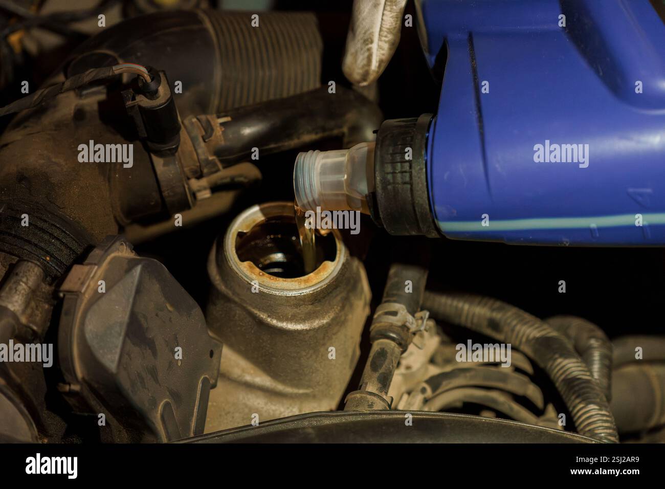 Car Mechanic Pouring Engine Oil Into The Oil Reservoir Stock Photo - Alamy
