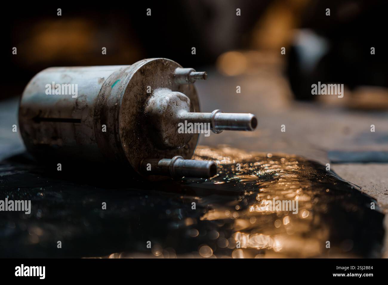 Rusty Fuel Filter on a Dark Garage Floor with Oil Puddle Stock Photo ...
