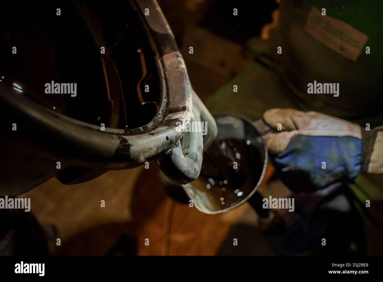 Industrial Worker Pouring Liquid from a Container into a Smaller Vessel ...
