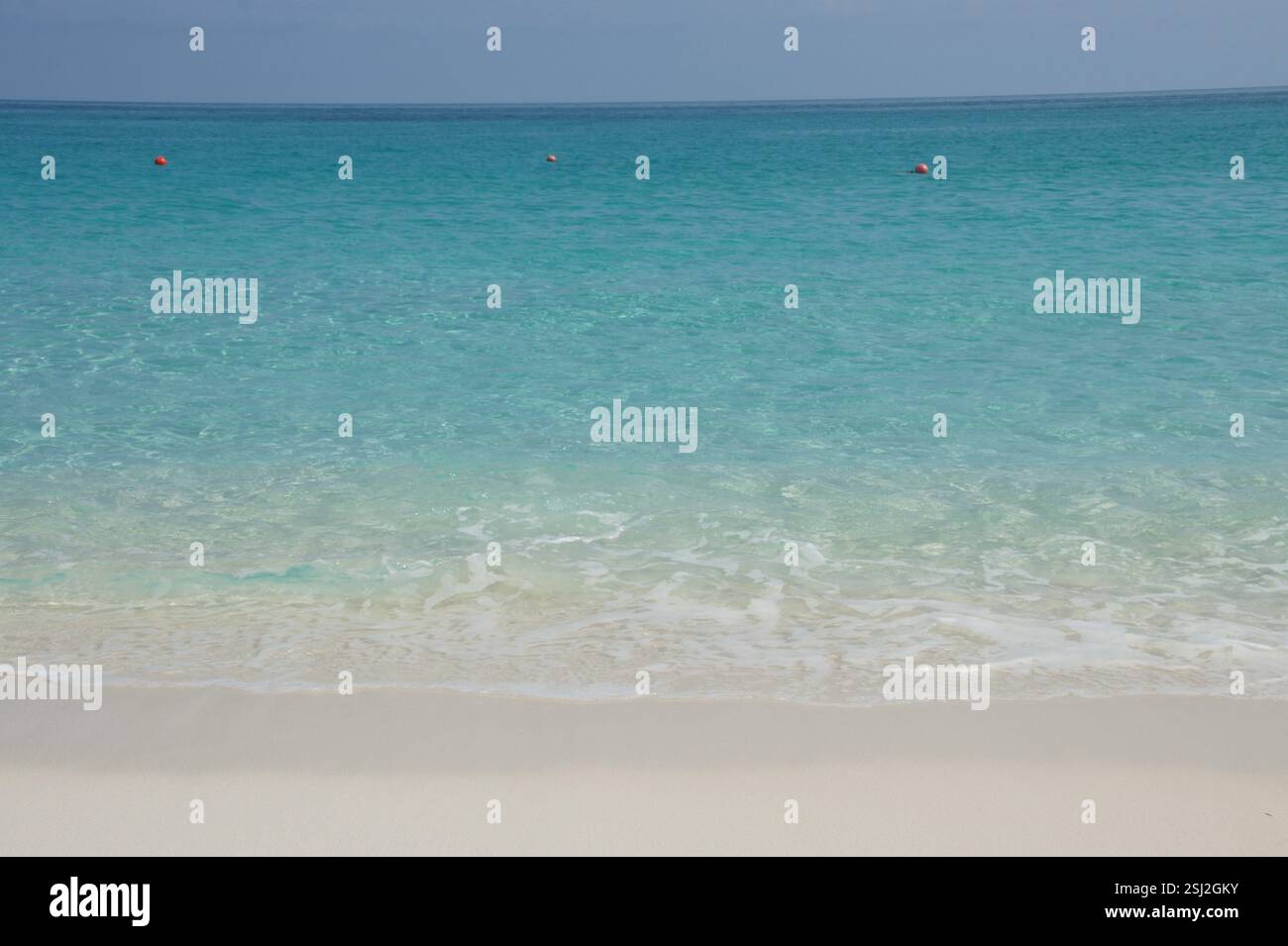 Beach. White sand meets crystal-clear turquoise water. Calm waves lap ...