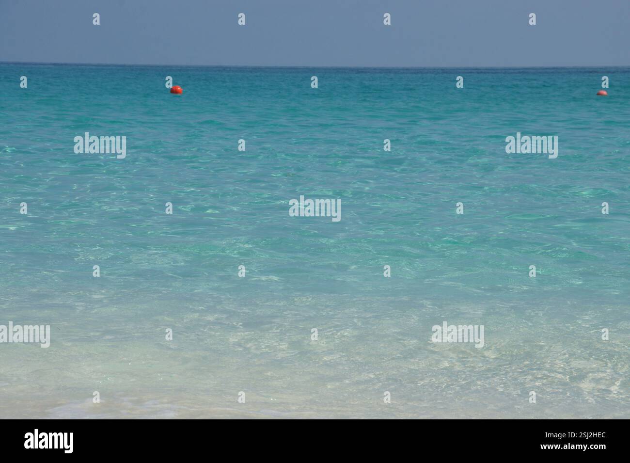 Beach. Calm turquoise water with small waves. Clear sky with a few ...