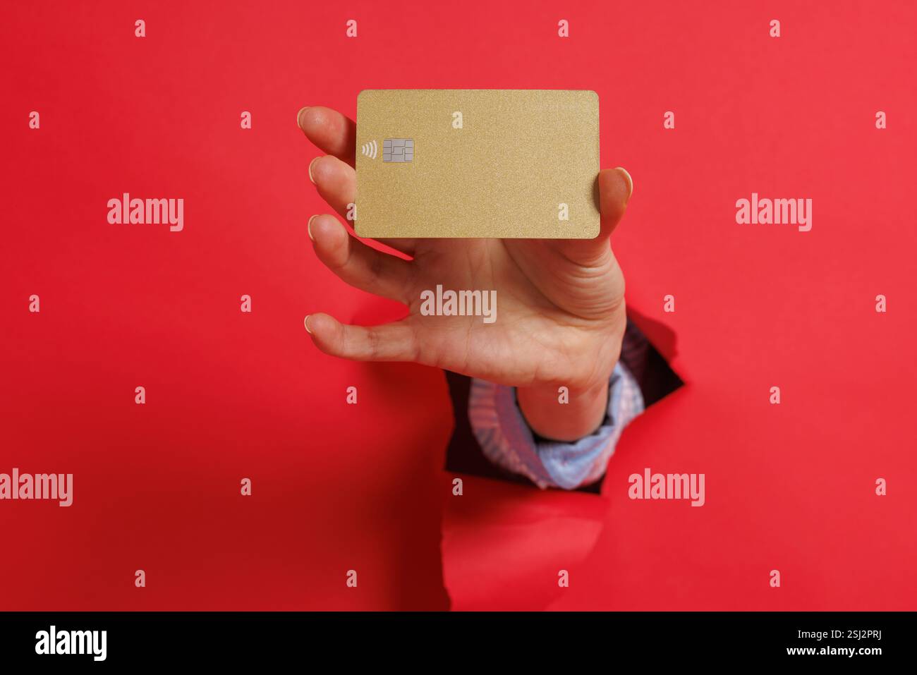 female hand holding credit card close-up on red background, online ...