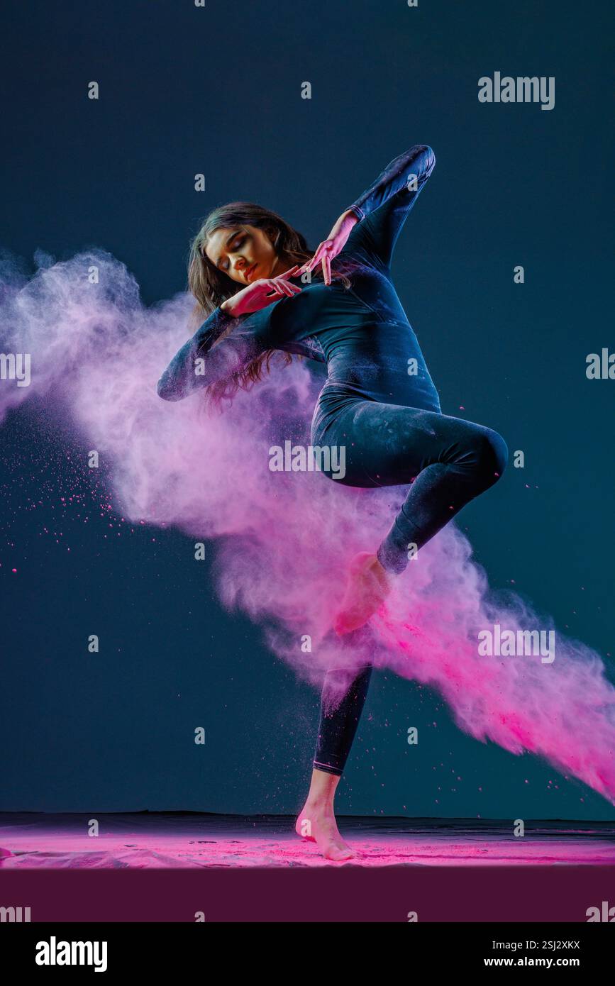 Dynamic female dancer in motion, surrounded by vibrant pink powder ...