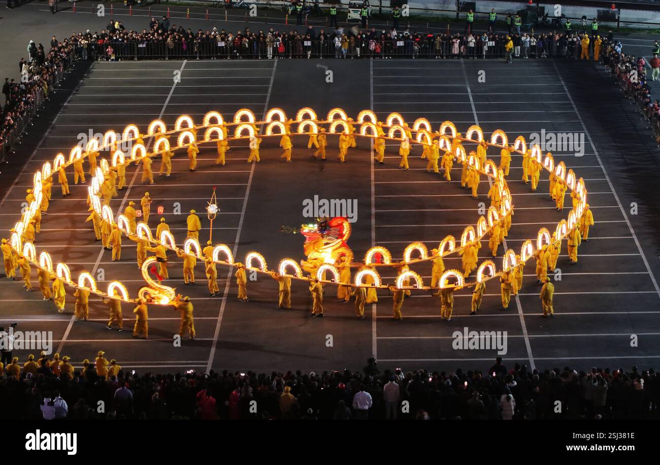 HANGZHOU, CHINA - FEBRUARY 11, 2025 - Tourists watch a dragon parade ...