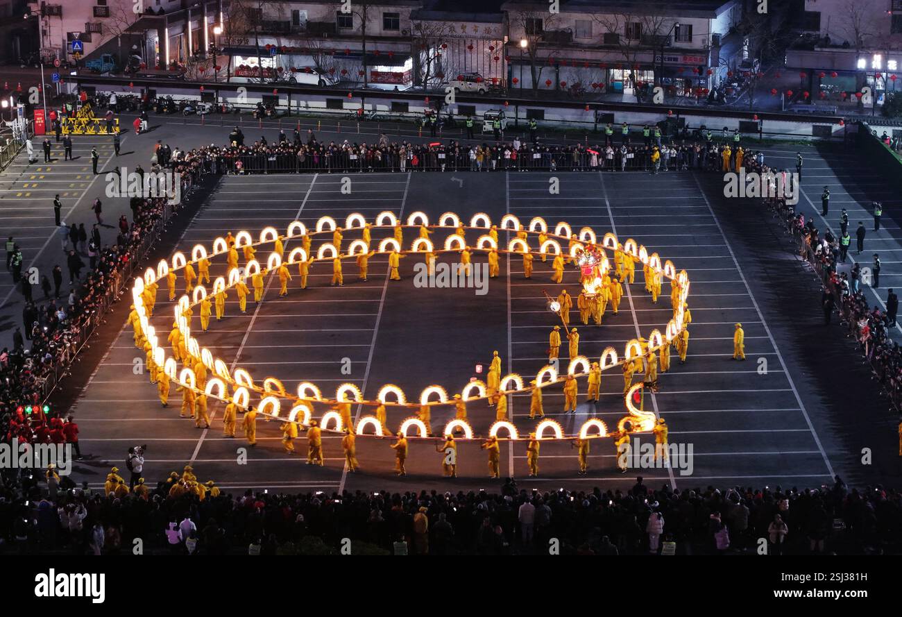 HANGZHOU, CHINA - FEBRUARY 11, 2025 - Tourists watch a dragon parade ...