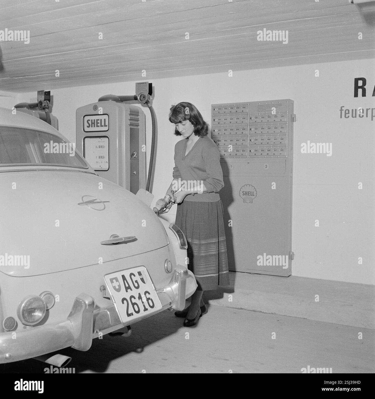 Frau tankt Benzin an Selbstbedienungstankstelle, 1956#Woman fills up ...