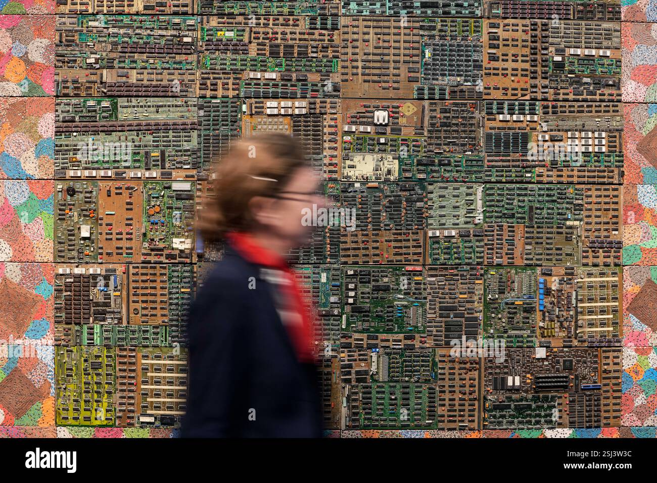 A woman passes large-scale artwork abstractions, made from thousands of ...