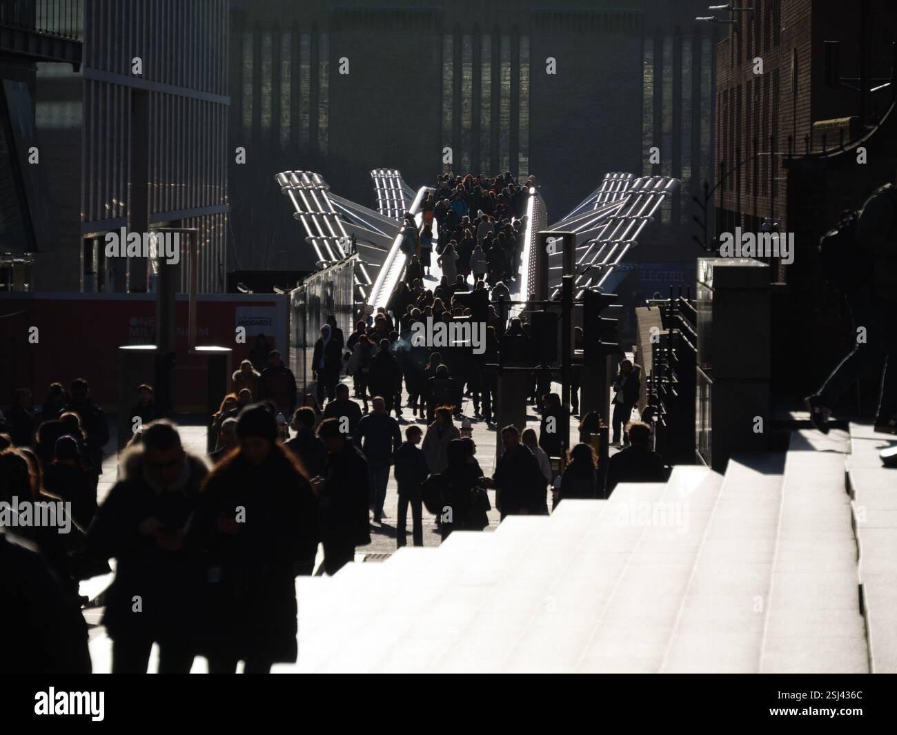 Busy crowds cross the iconic Millennium Bridge, a pedestrian pathway ...