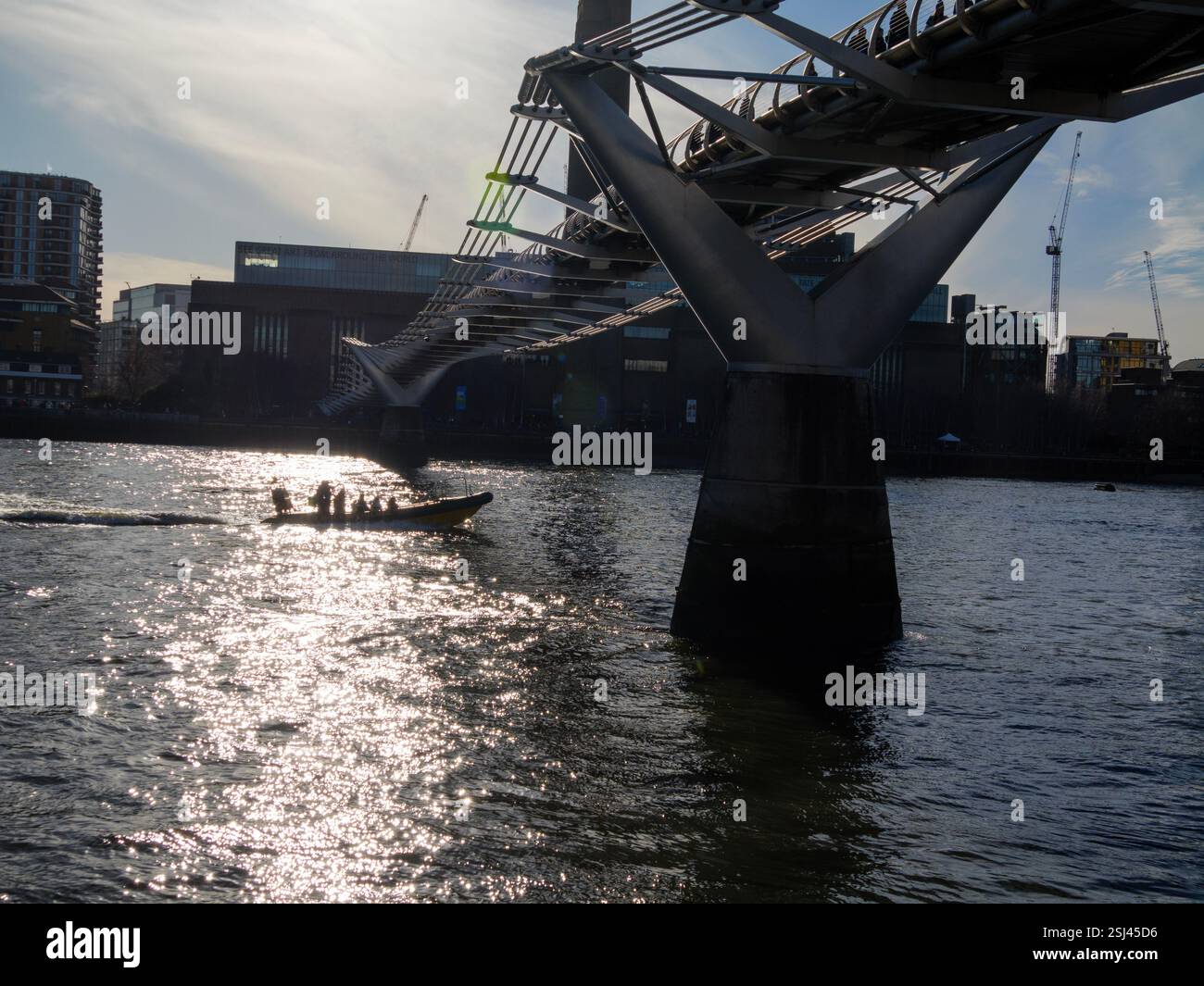 Busy crowds navigate the iconic Millennium Bridge, a pedestrian walkway ...
