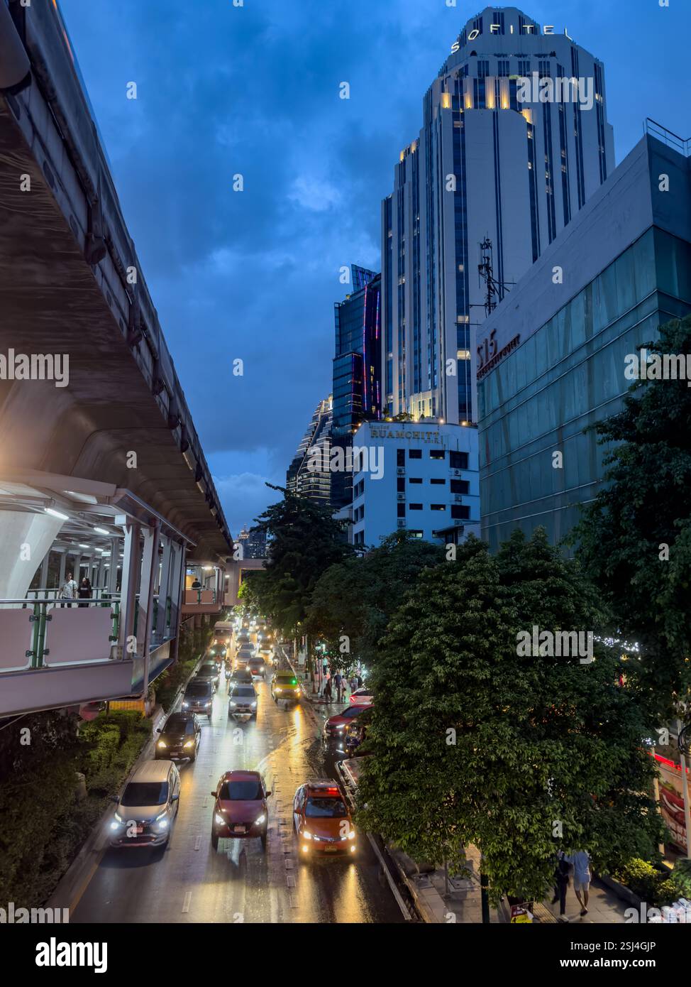 A vibrant evening scene on Sukhumvit Road in Bangkok, featuring ...
